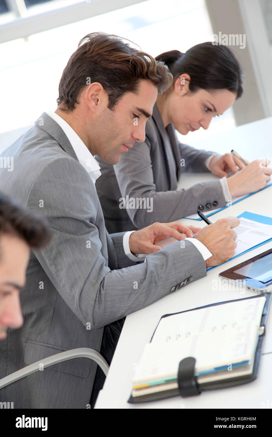 Young people signing application form Stock Photo - Alamy