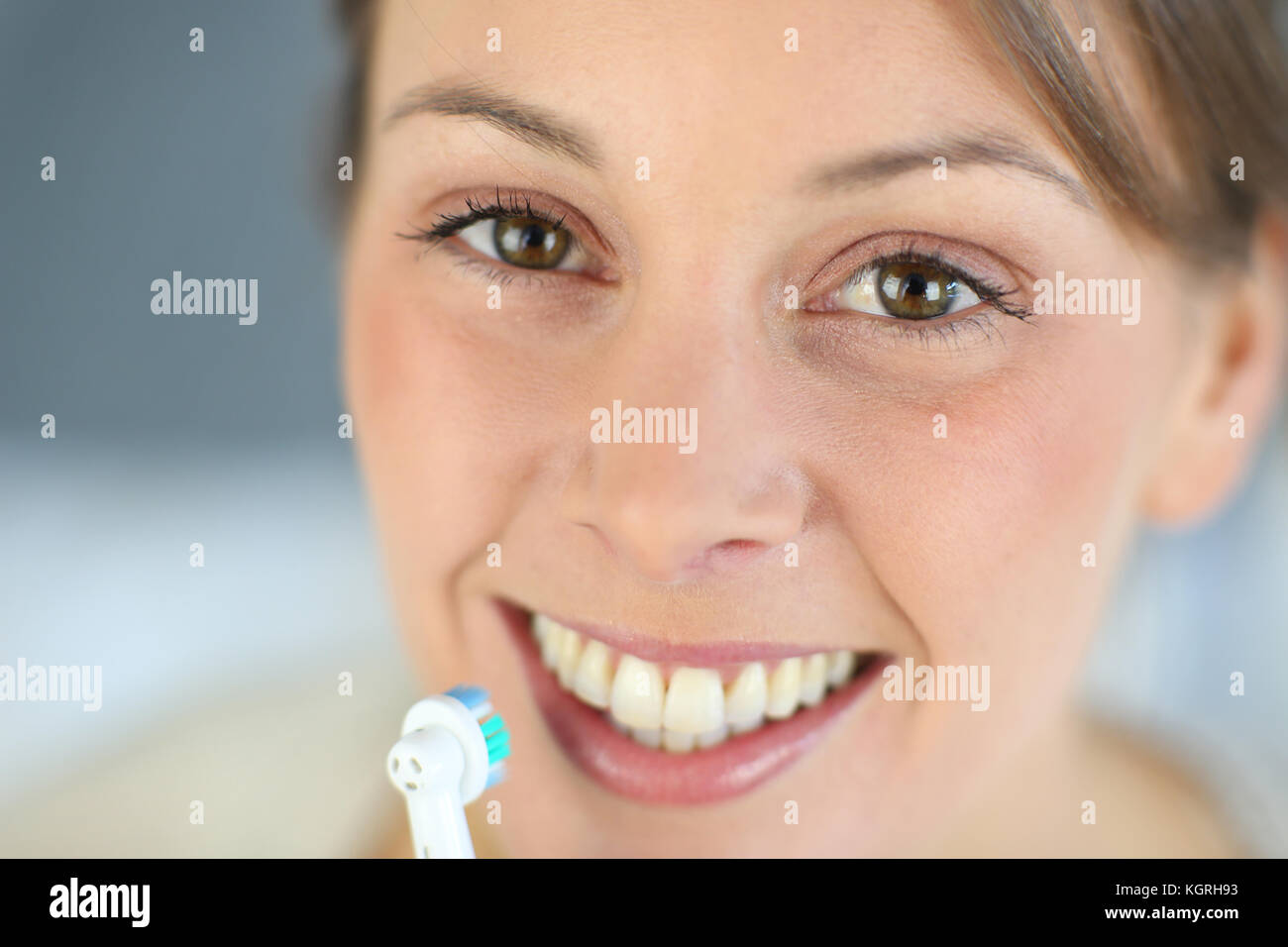 Closeup on woman's toothy smile brushing her teeth Stock Photo - Alamy