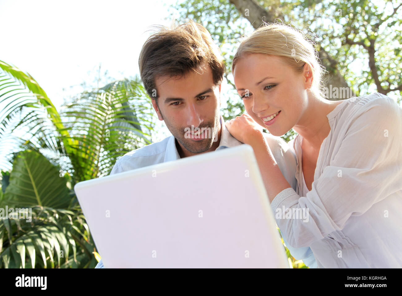 Young couple connected on internet sitting in longchairs Stock Photo ...