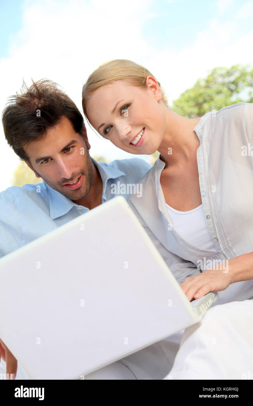 Young couple connected on internet sitting in longchairs Stock Photo ...