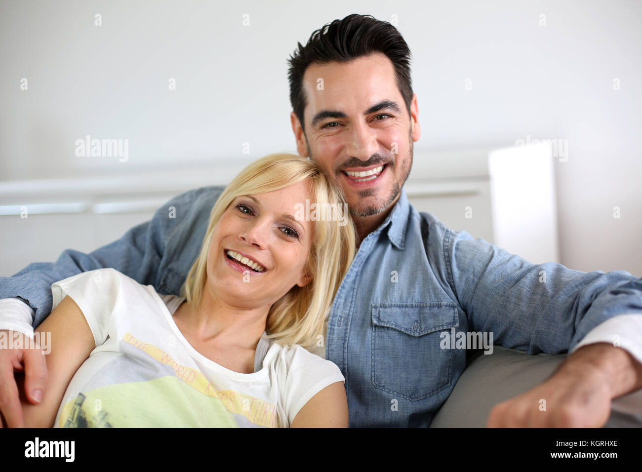 Sweet middle-aged couple embracing in sofa Stock Photo - Alamy