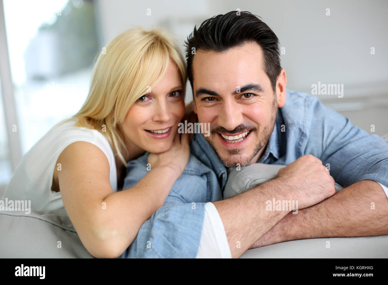 Sweet middle-aged couple embracing in sofa Stock Photo - Alamy