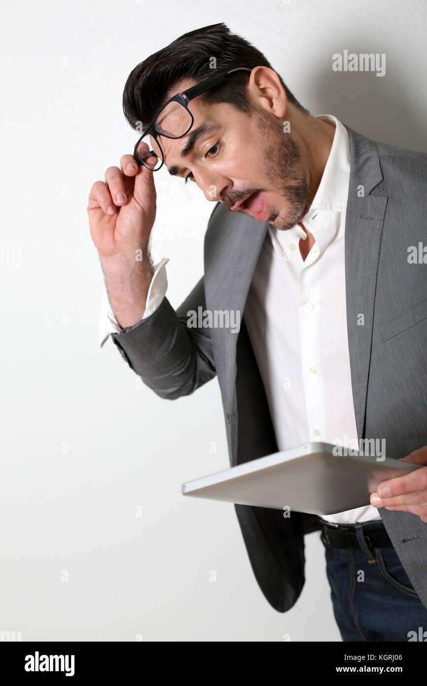 Man looking at tablet with surprised look Stock Photo - Alamy