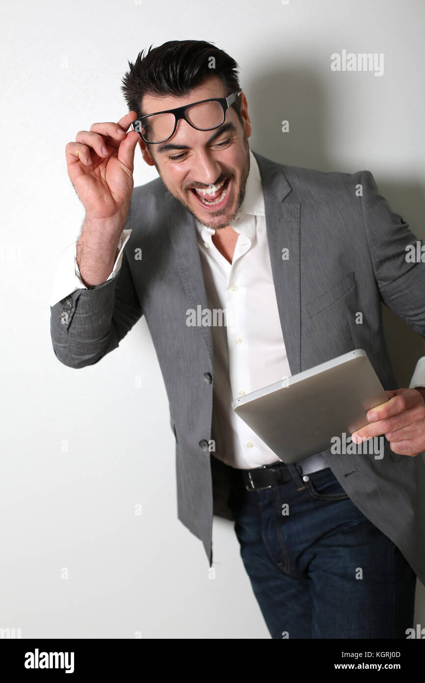 Man looking at tablet with surprised look Stock Photo - Alamy