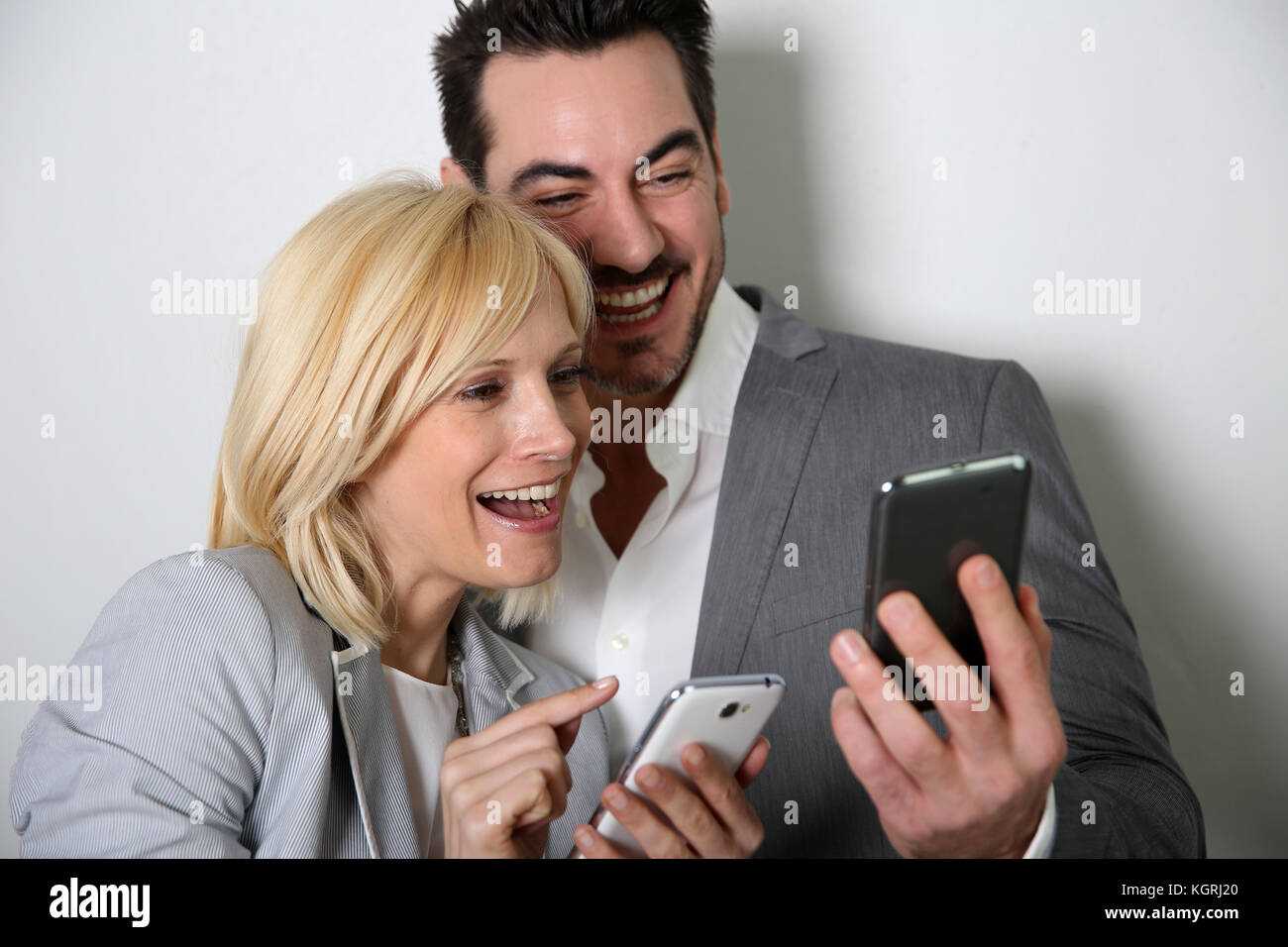 Couple using smartphone together Stock Photo - Alamy