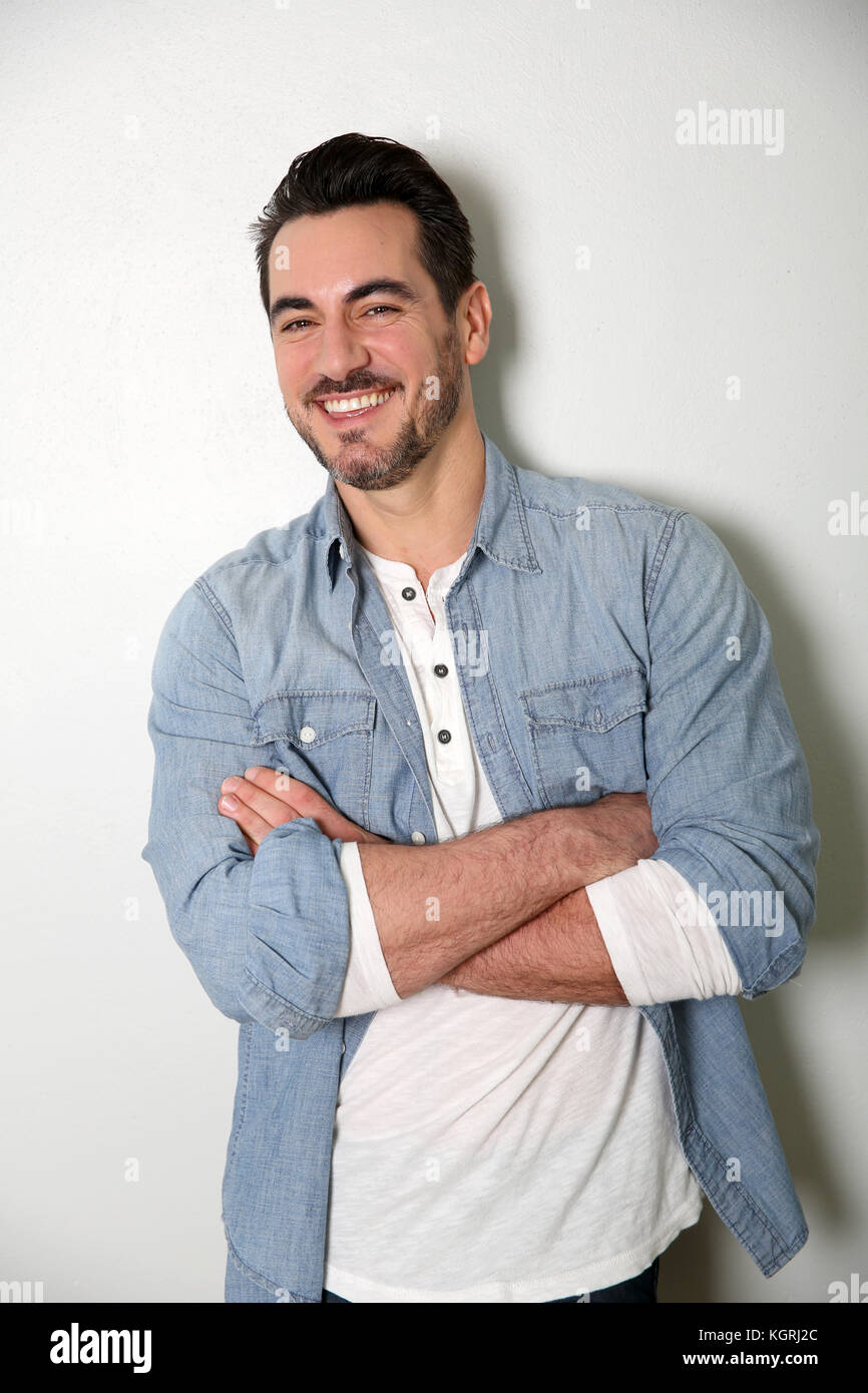 Man with blue shirt standing on white background Stock Photo - Alamy