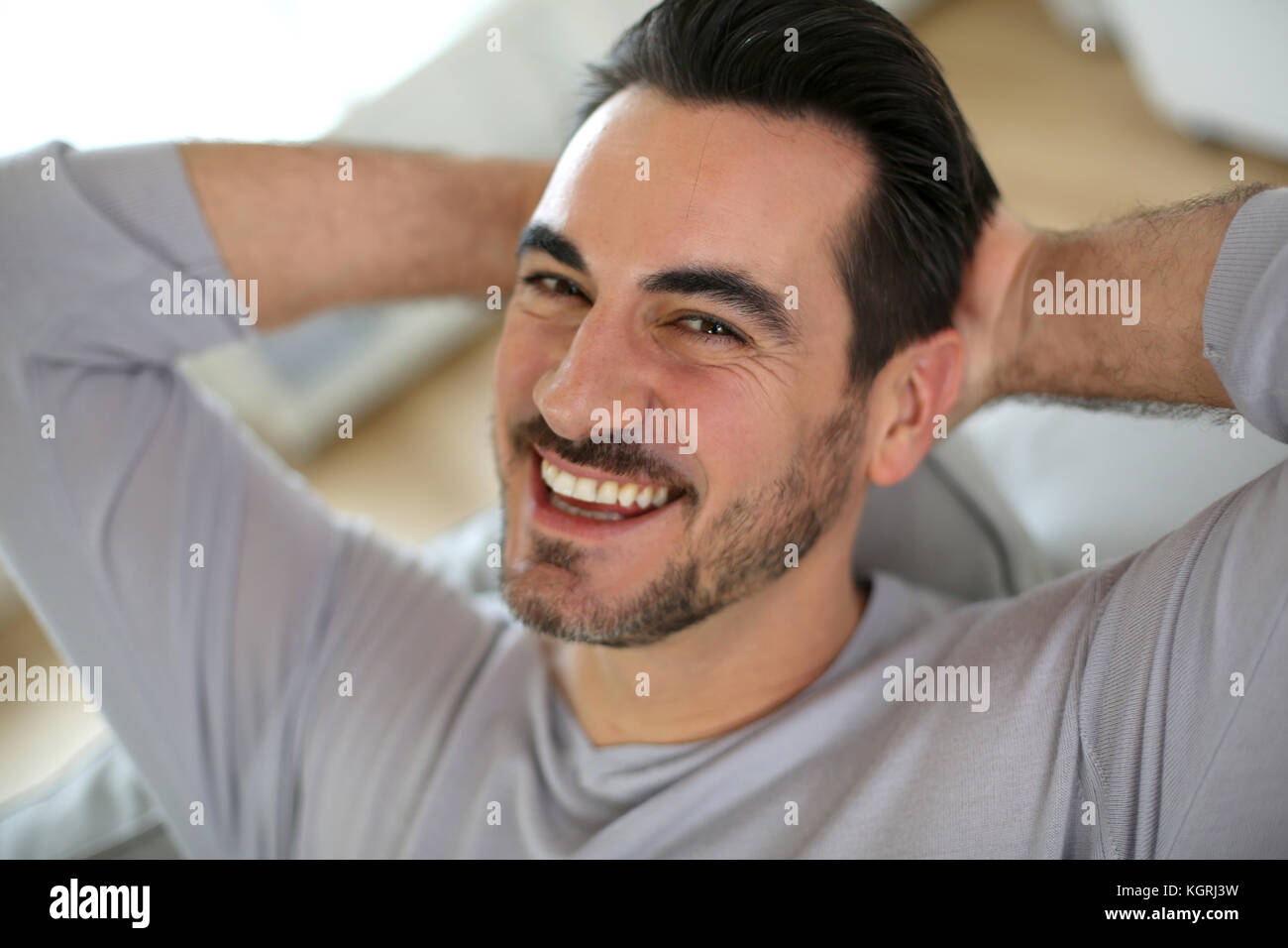 Relaxed man stretching arms behind head Stock Photo - Alamy