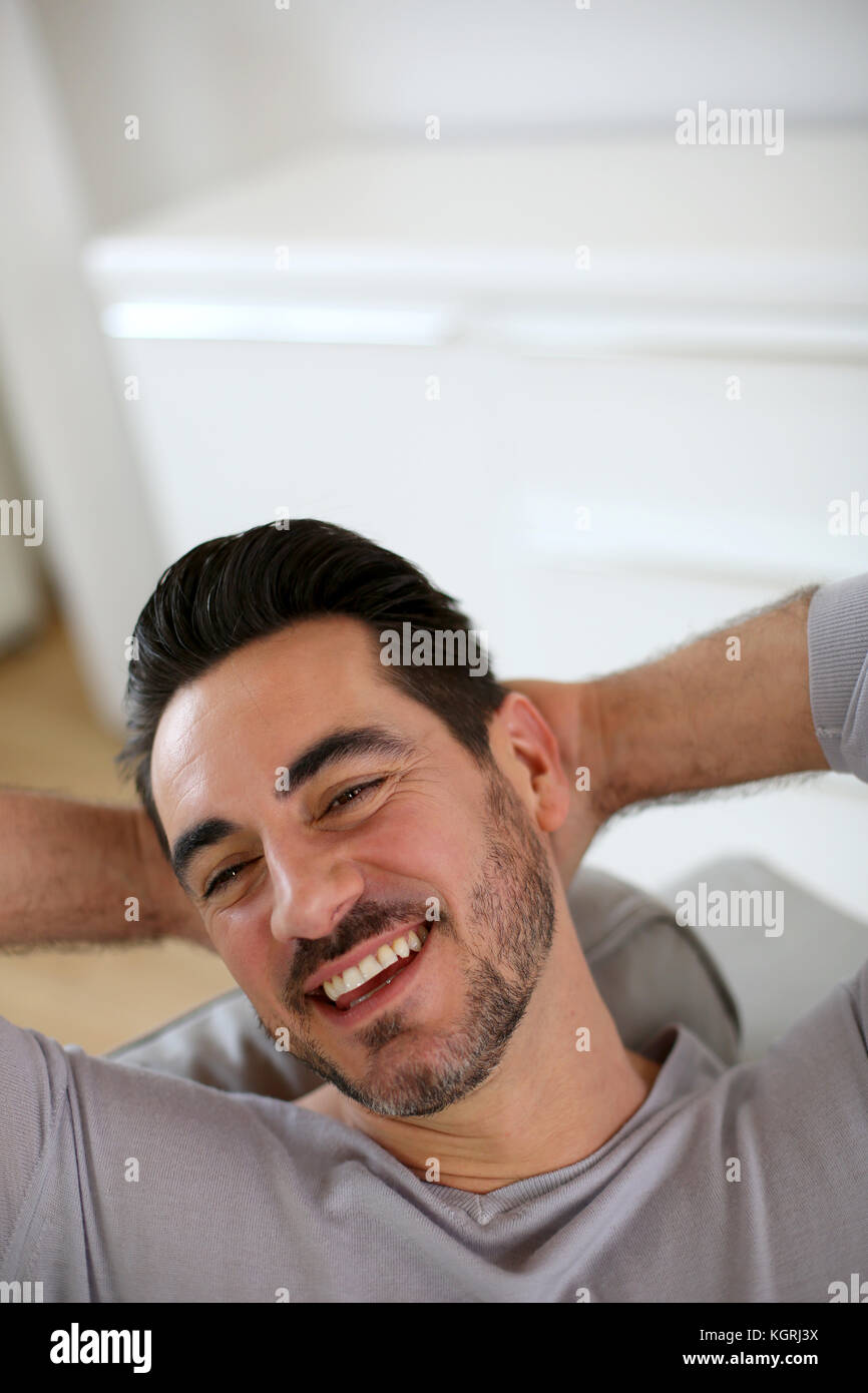 Relaxed man stretching arms behind head Stock Photo - Alamy