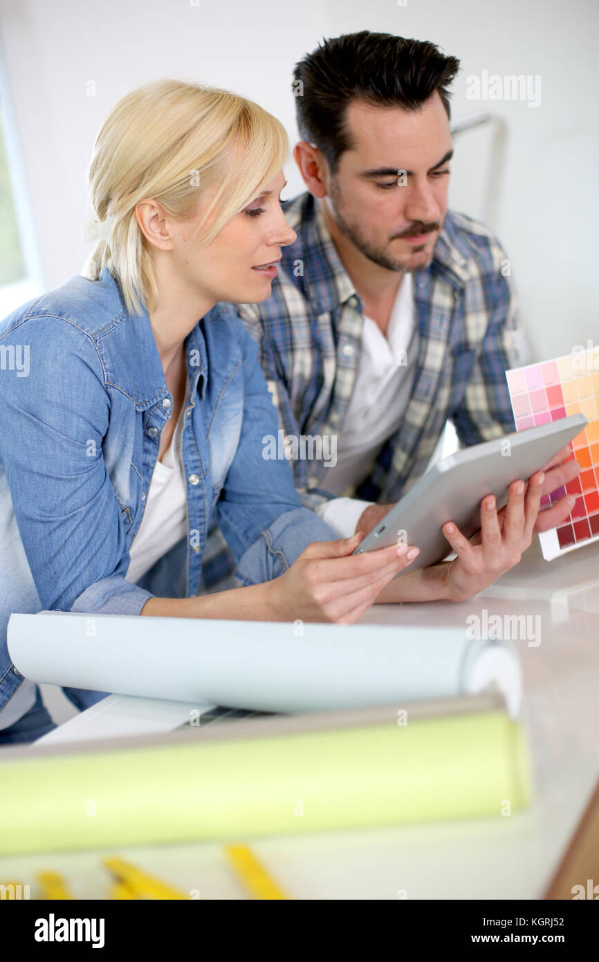 Middle-aged couple choosing wall colours for new home Stock Photo - Alamy