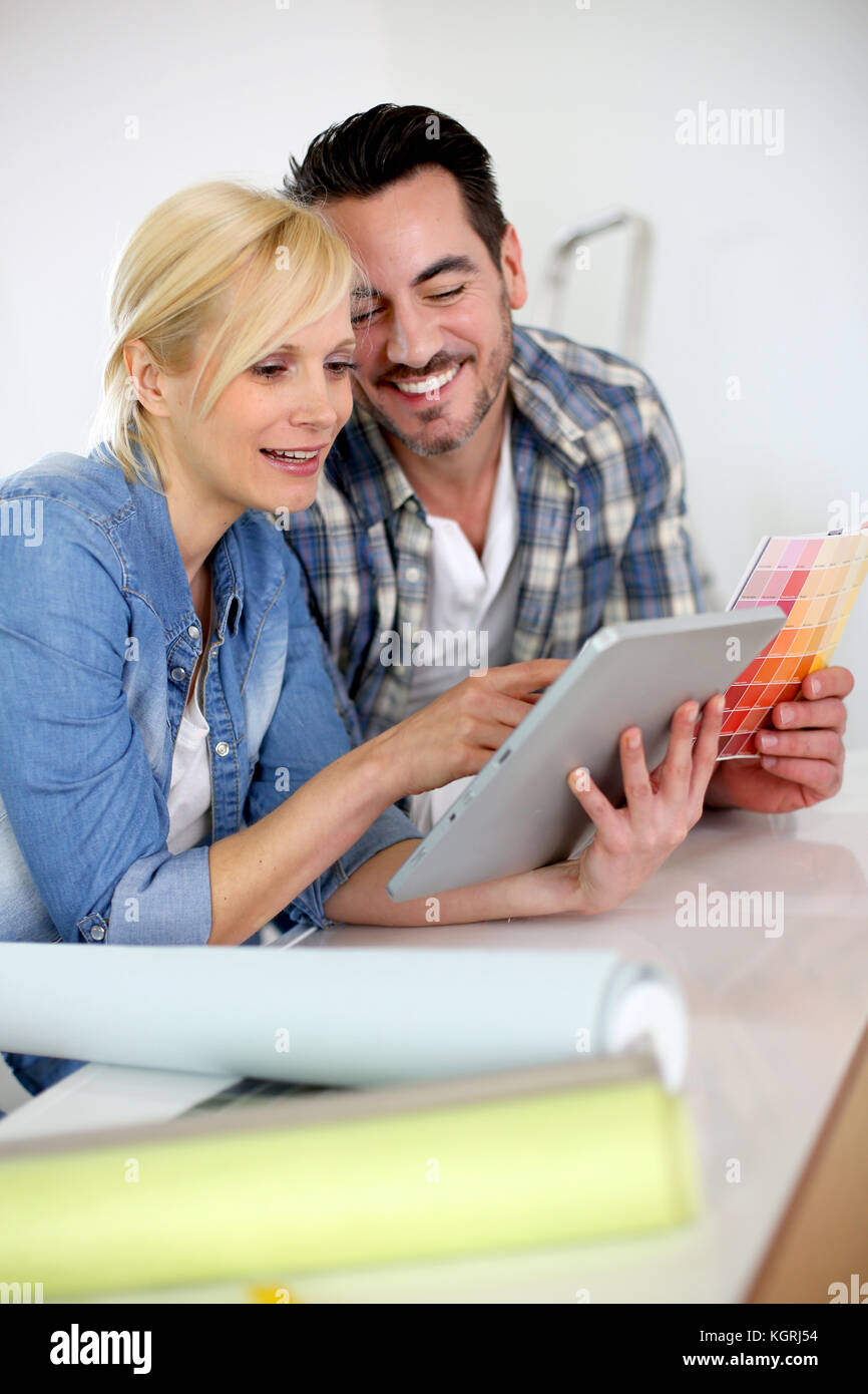 Middle-aged couple choosing wall colours for new home Stock Photo - Alamy