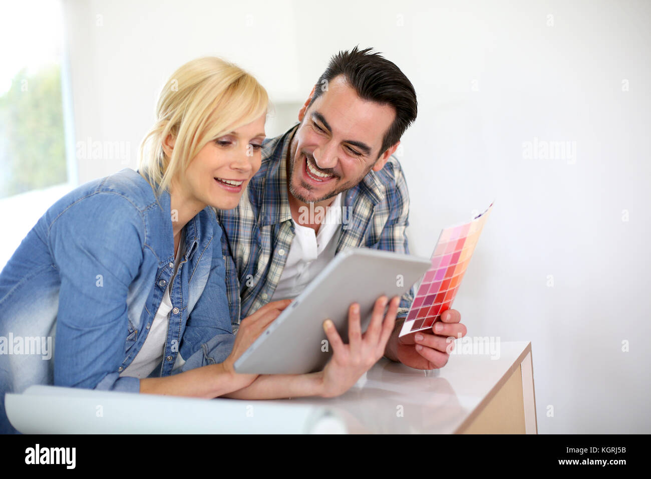 Middle-aged couple choosing wall colours for new home Stock Photo - Alamy