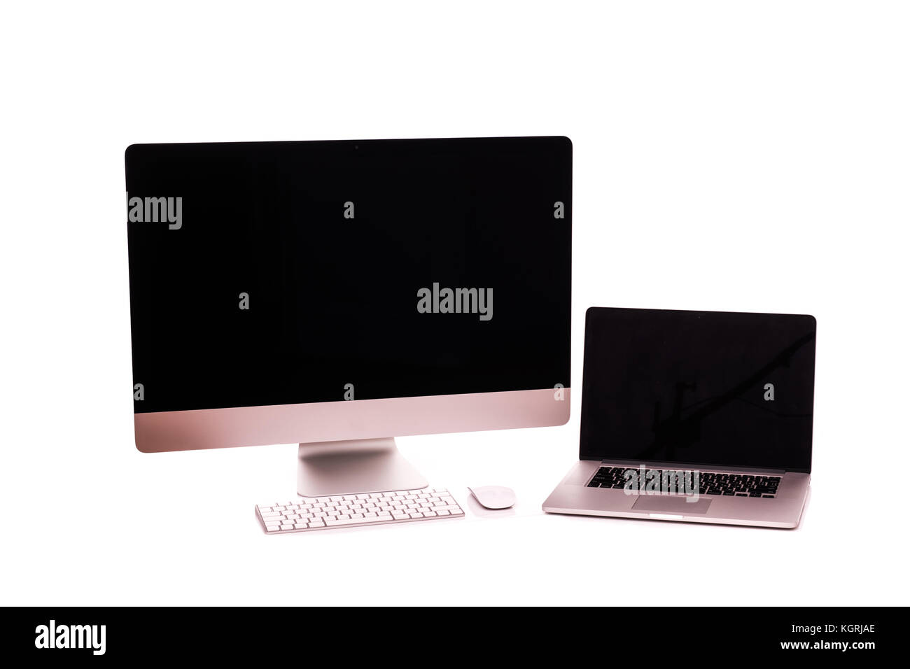 Laptop and computer screen on a white table with reflection on white ...