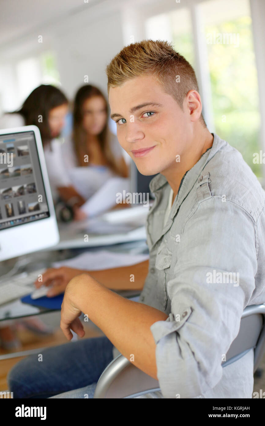 Young man sitting in office in front of desktop computer Stock Photo ...