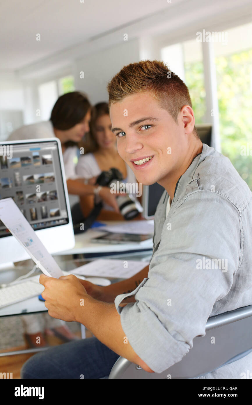 Young man sitting in office in front of desktop computer Stock Photo ...