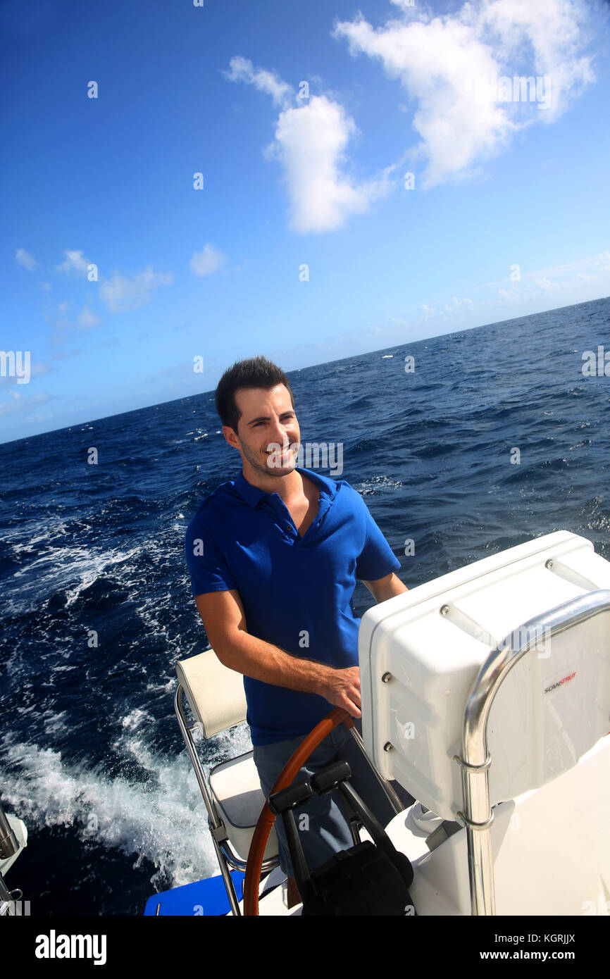 Smiling young sailor navigating in Caribbean sea Stock Photo - Alamy