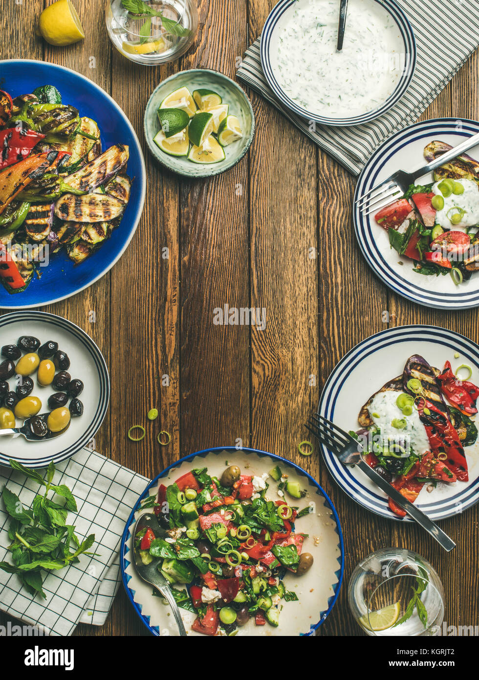 Flat-lay of healthy dinner table setting. Fresh salad, grilled ...