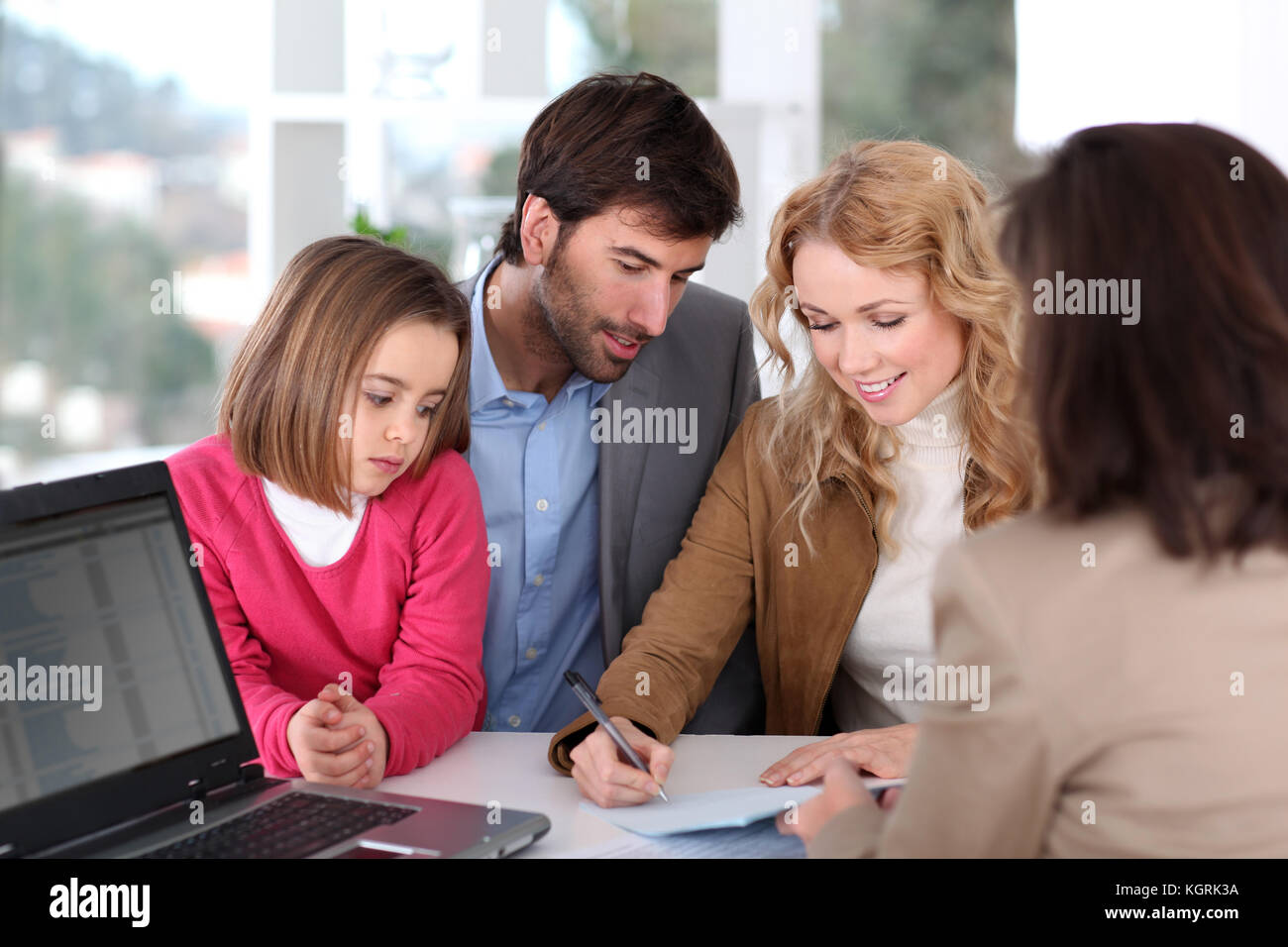Family signing real-estate contract Stock Photo - Alamy