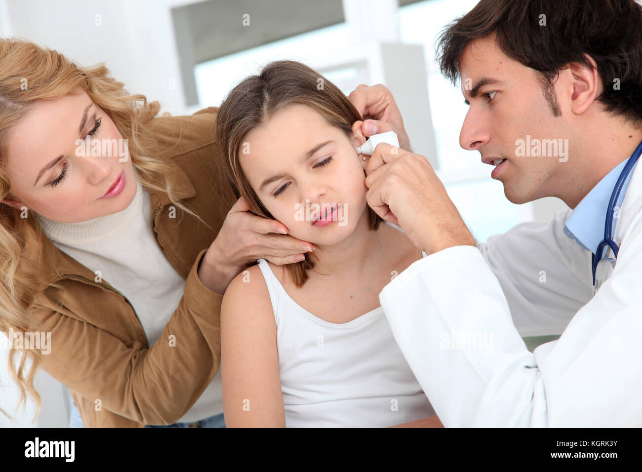 Doctor looking at little girl ear infection Stock Photo - Alamy