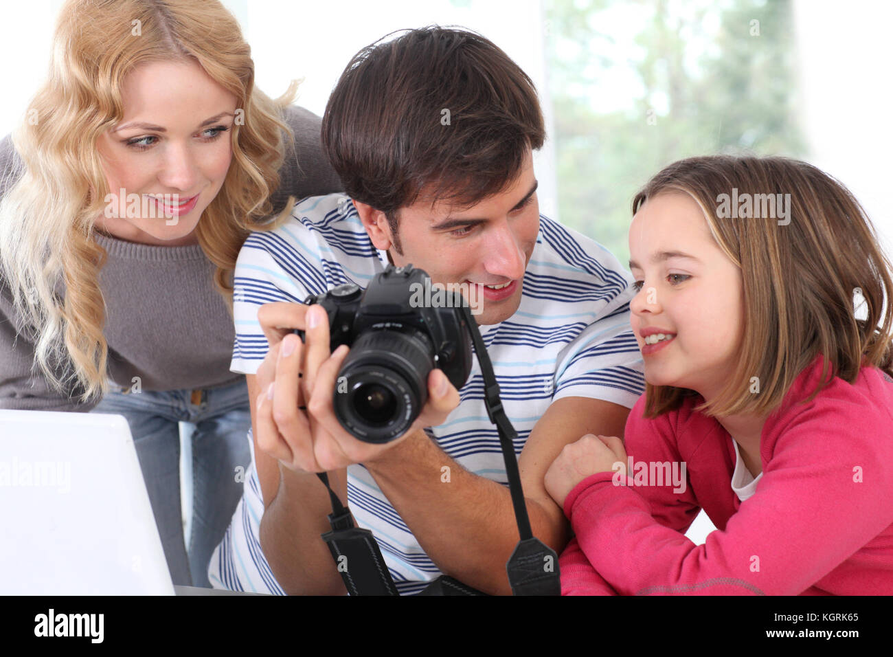 Family looking at pictures on camera screen Stock Photo - Alamy