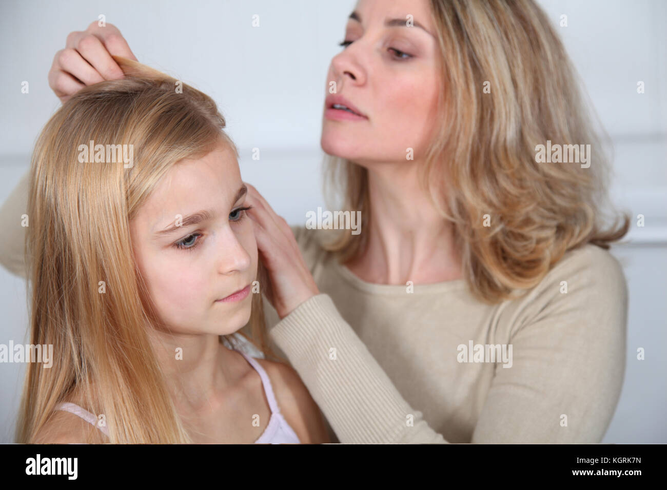 Mother treating daughter's hair against lice Stock Photo - Alamy