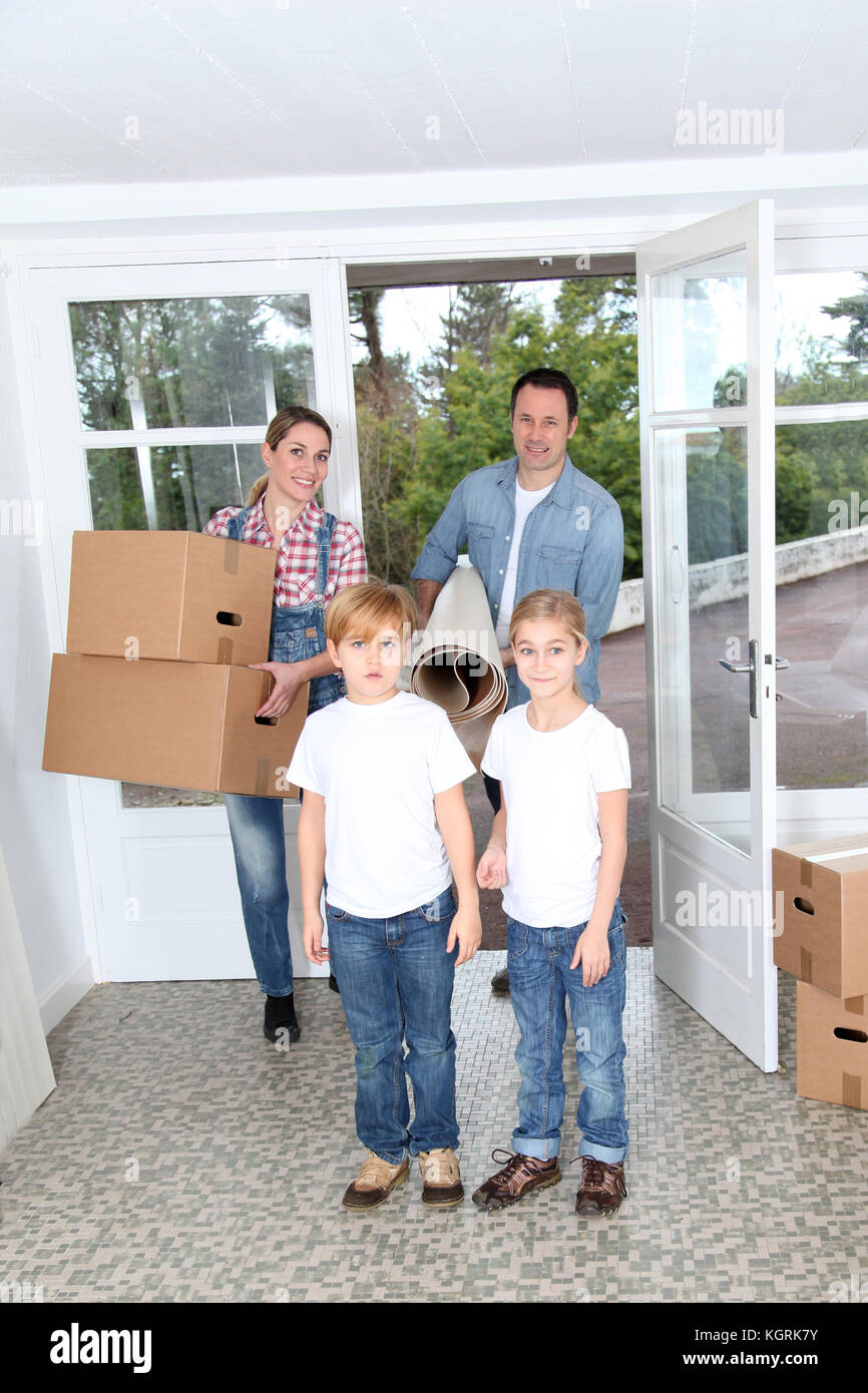 Family of 4 people moving in new home Stock Photo - Alamy