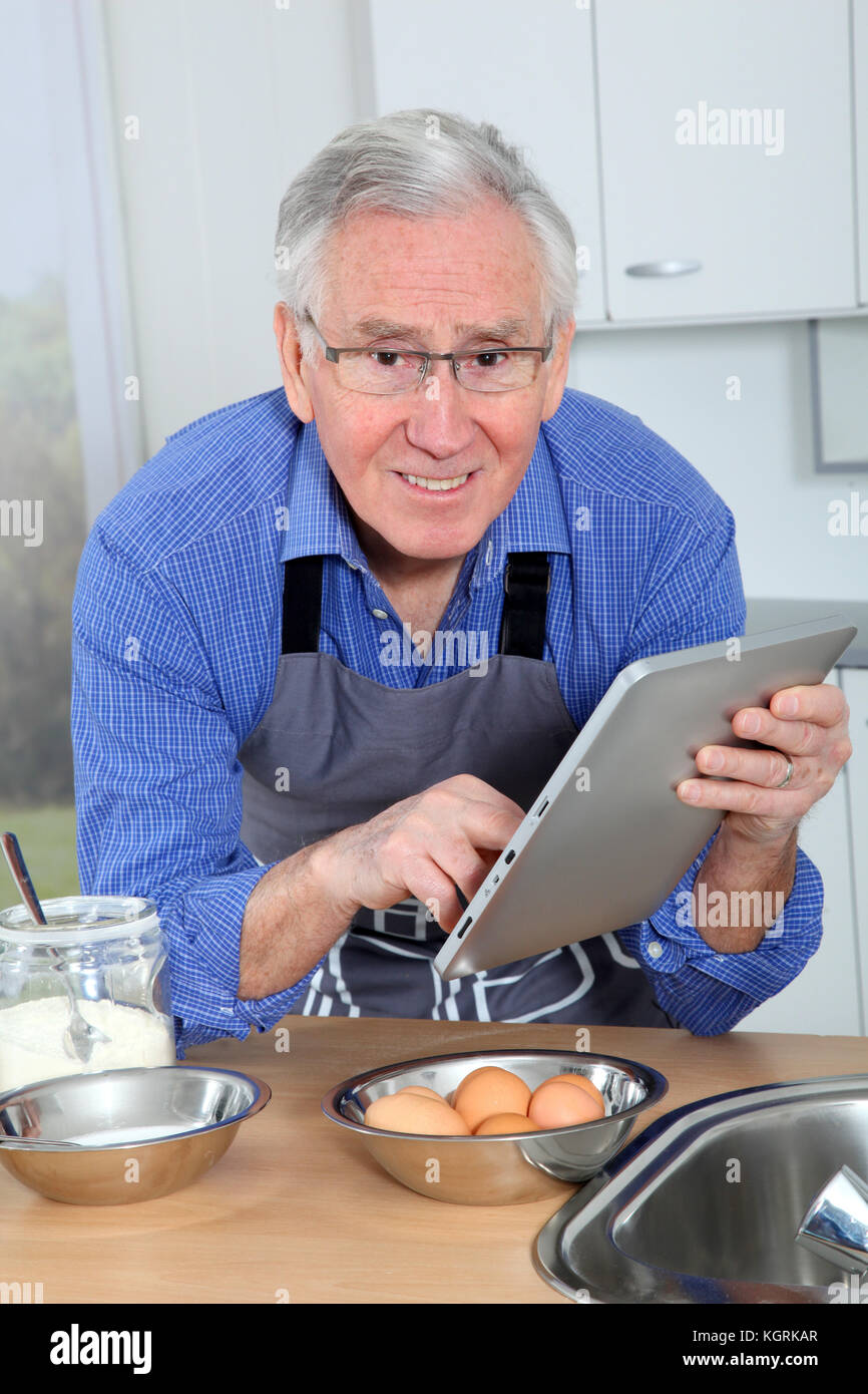 Elderly man looking at recipe on electronic tab Stock Photo - Alamy