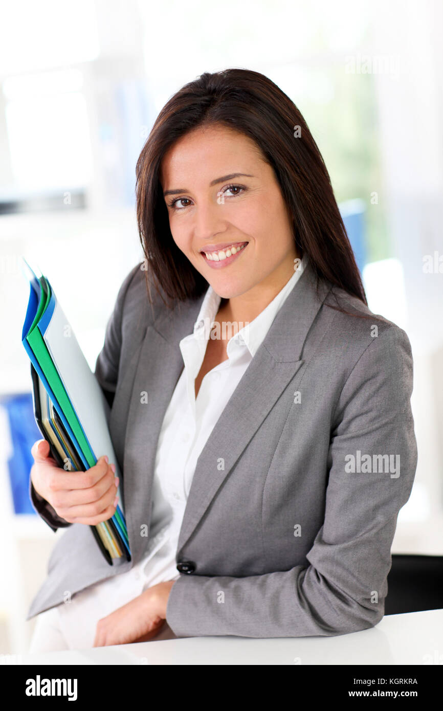 Cheerful saleswoman holding files Stock Photo - Alamy