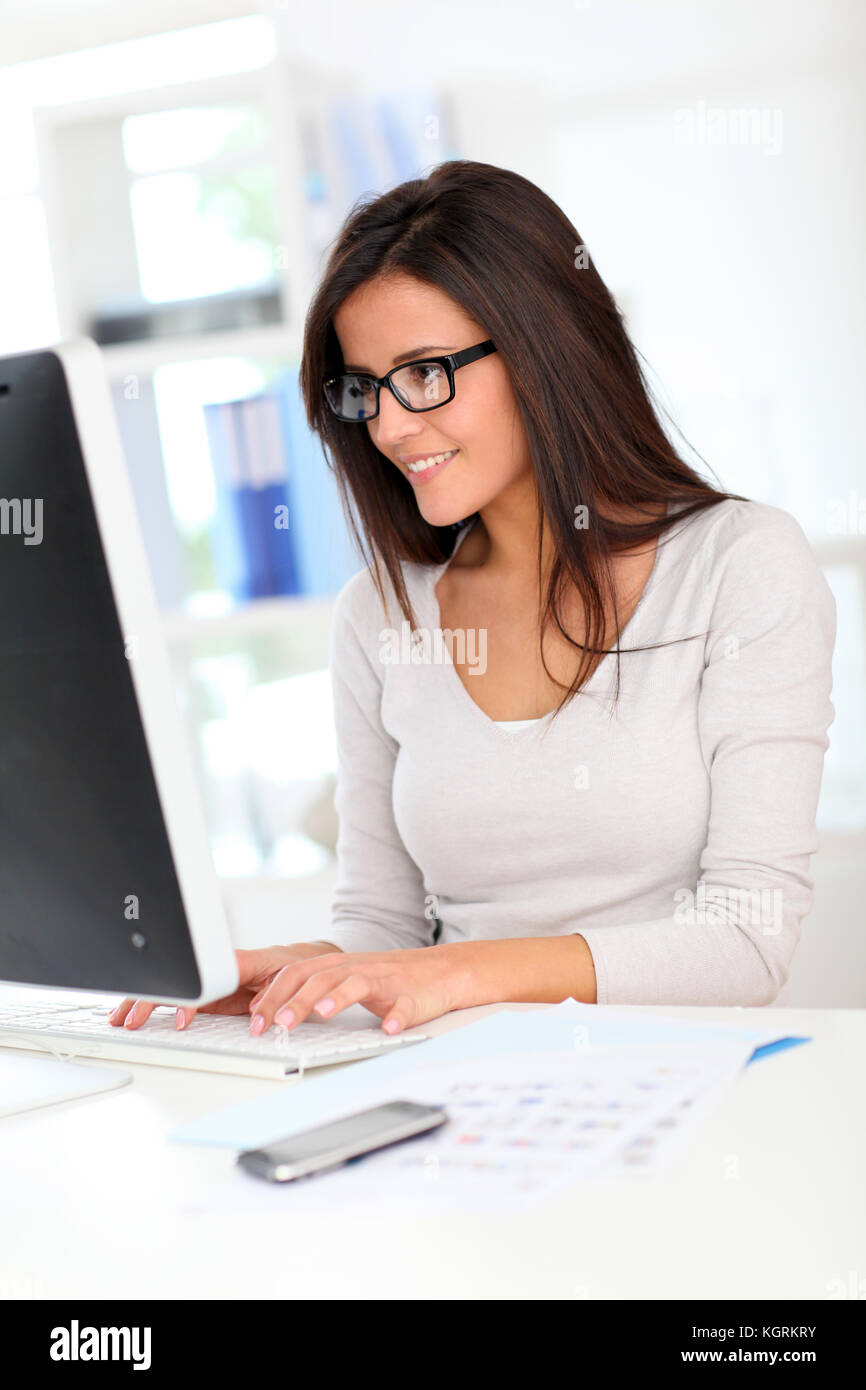 Beautiful office worker in front of desktop computer Stock Photo - Alamy