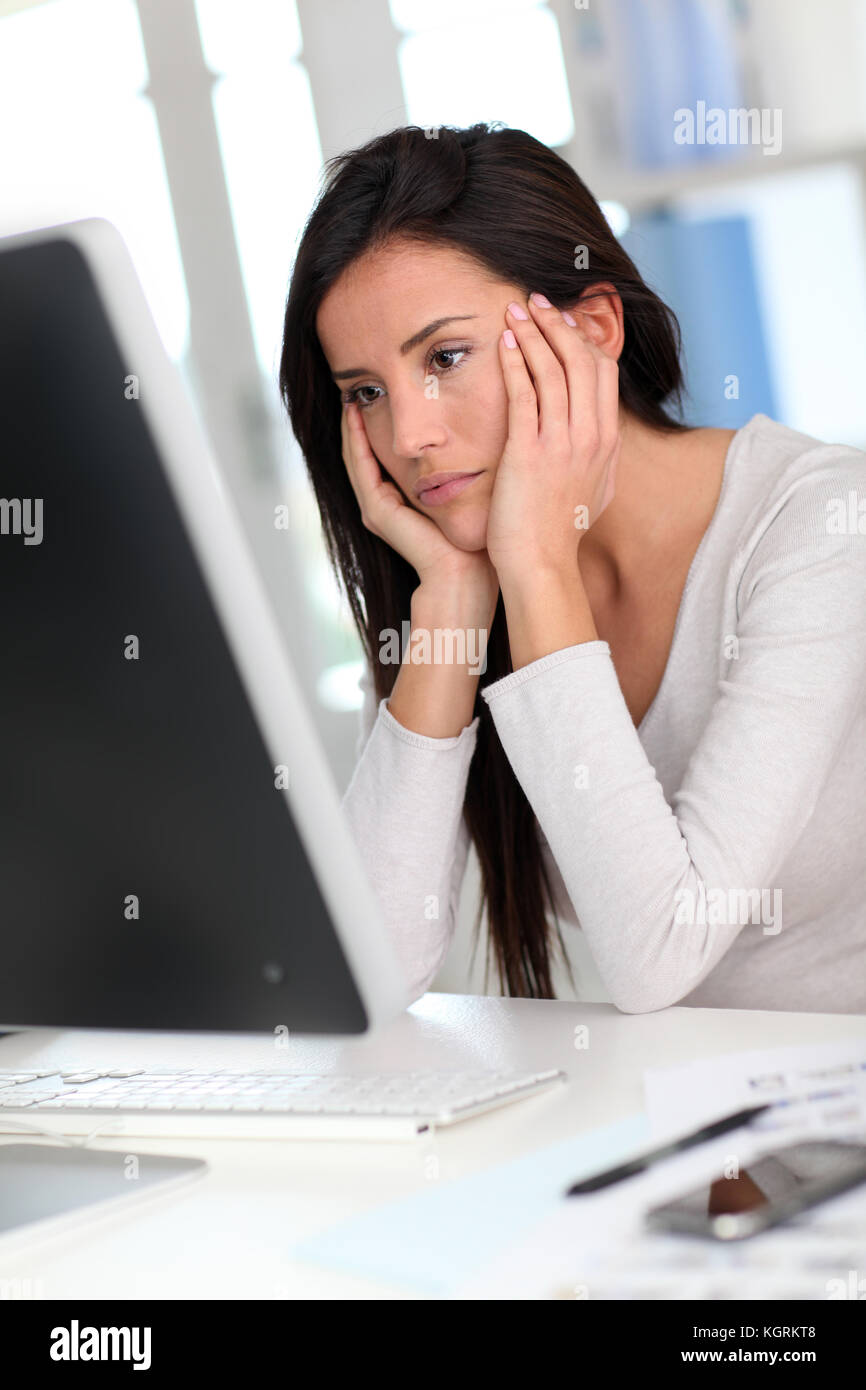 Woman in front of desktop computer having a headache Stock Photo - Alamy