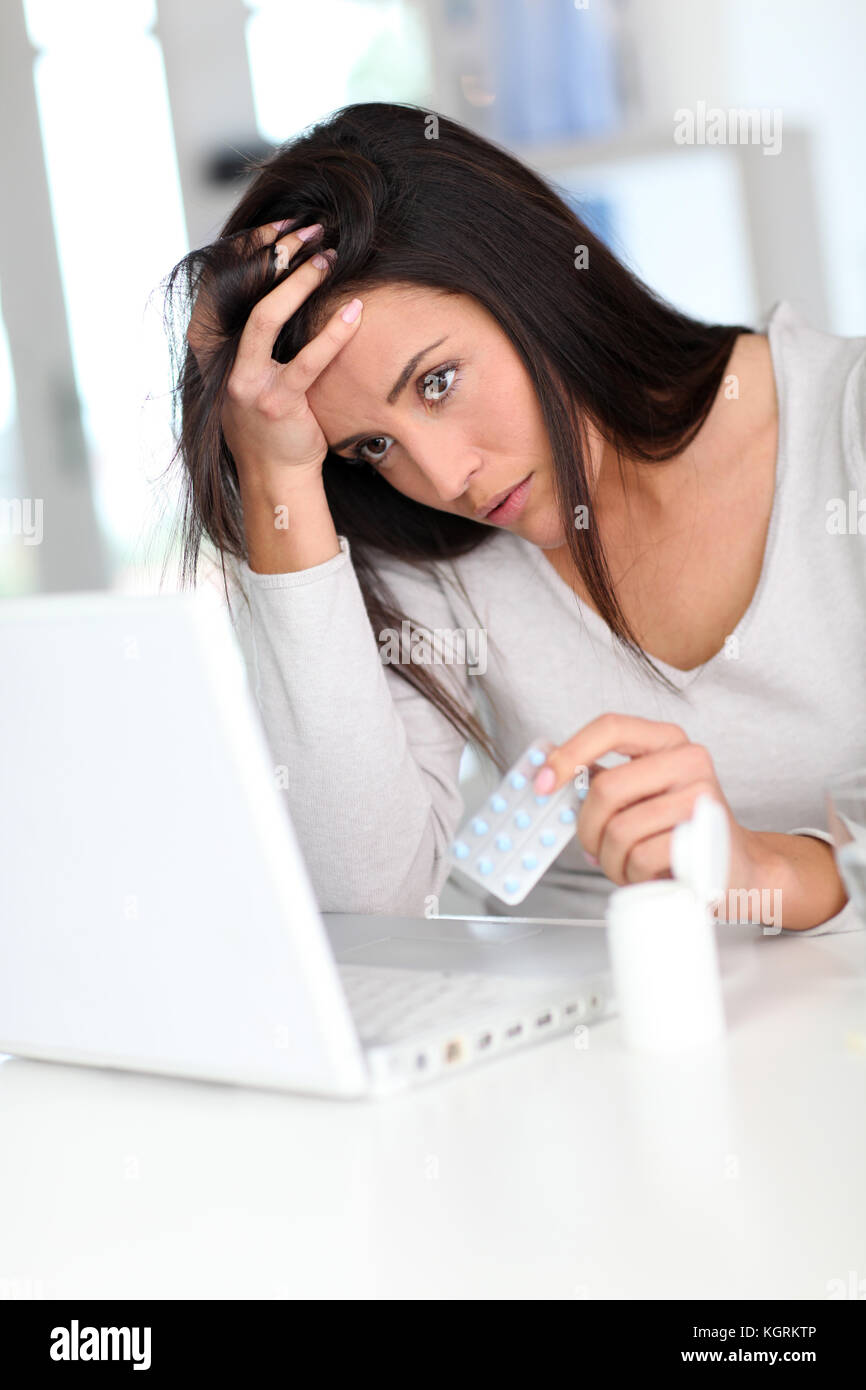 Woman with headache in front of laptop computer Stock Photo - Alamy