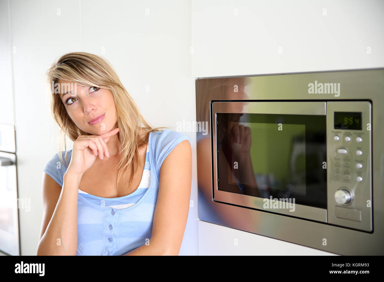 Portrait of woman by microwave oven Stock Photo - Alamy