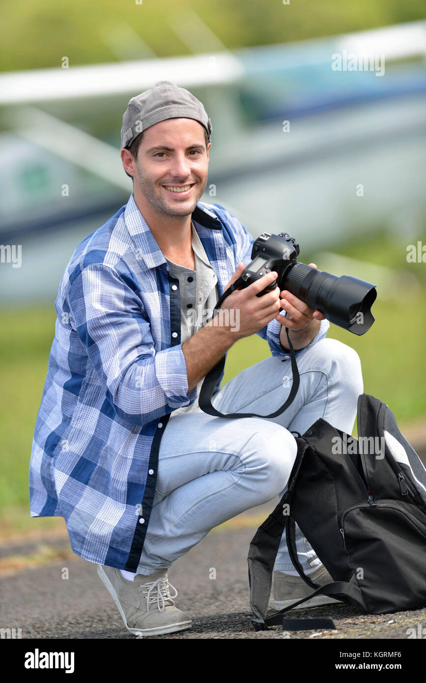 Photographer taking camera out of backpack Stock Photo - Alamy
