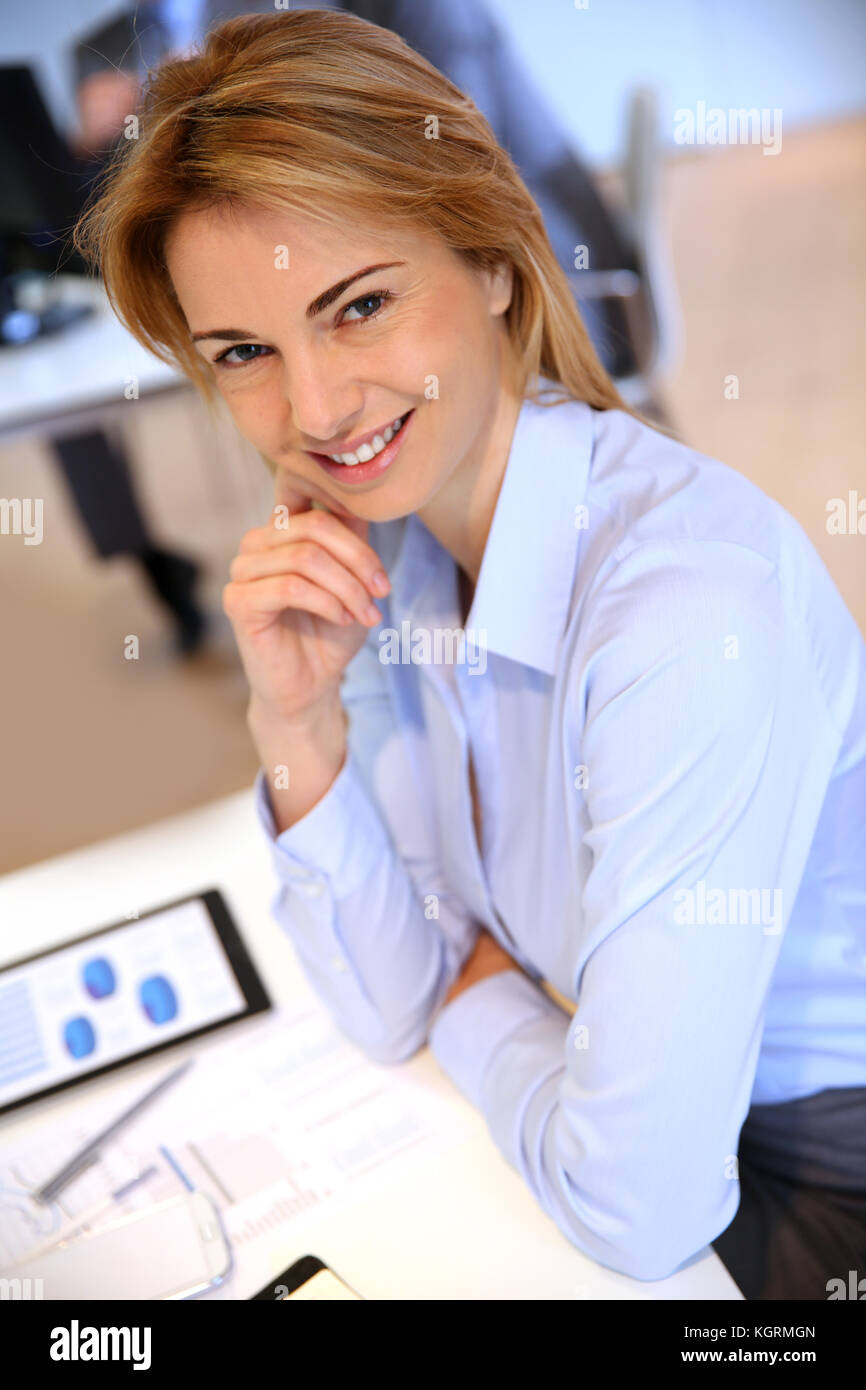 Beautiful office worker sitting at her desk Stock Photo - Alamy