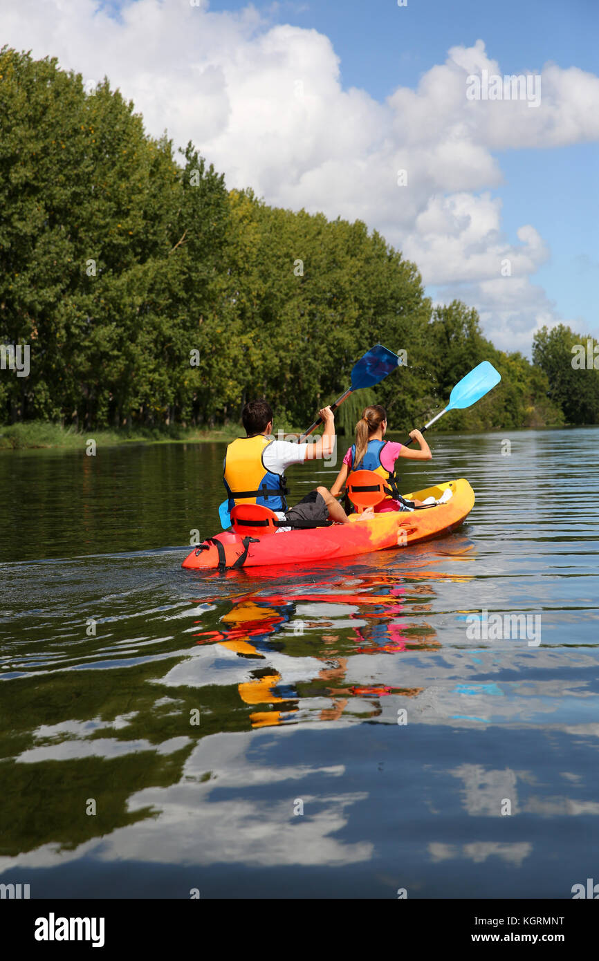 Couple riding canoe in river Stock Photo - Alamy