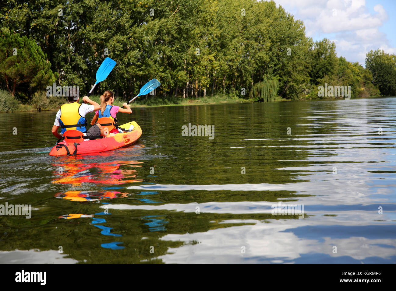 Couple riding canoe in river Stock Photo - Alamy