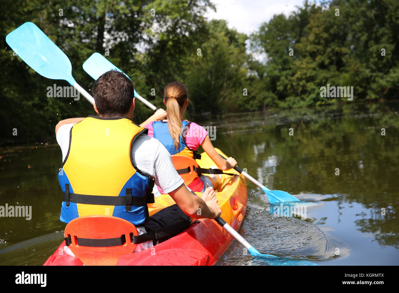 Couple riding canoe in river Stock Photo - Alamy