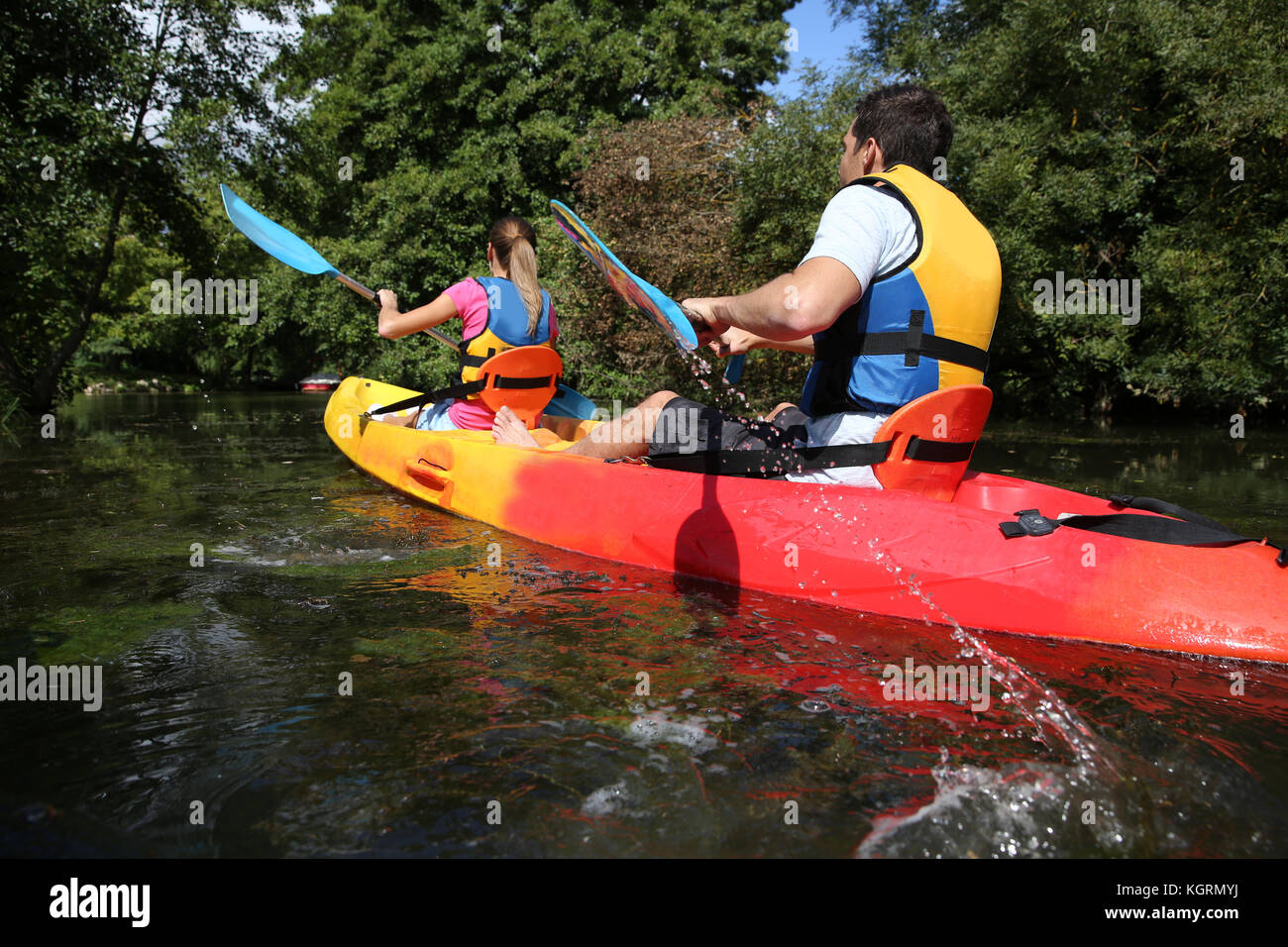 Couple riding canoe in river Stock Photo - Alamy