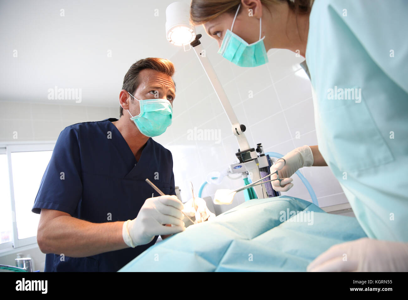 Surgeon with assistant doing surgery in clinic Stock Photo - Alamy