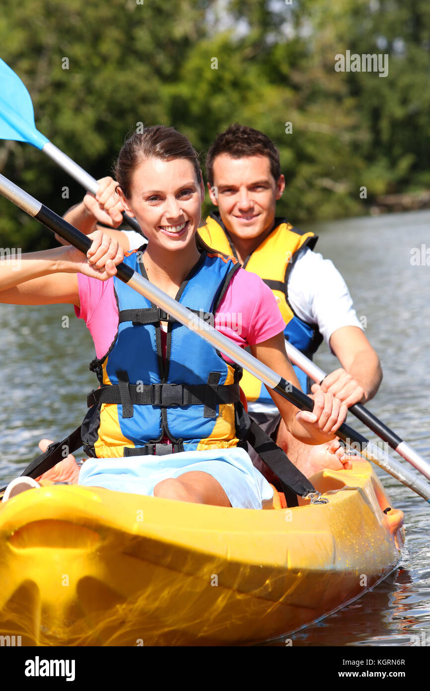Couple riding canoe in river Stock Photo - Alamy