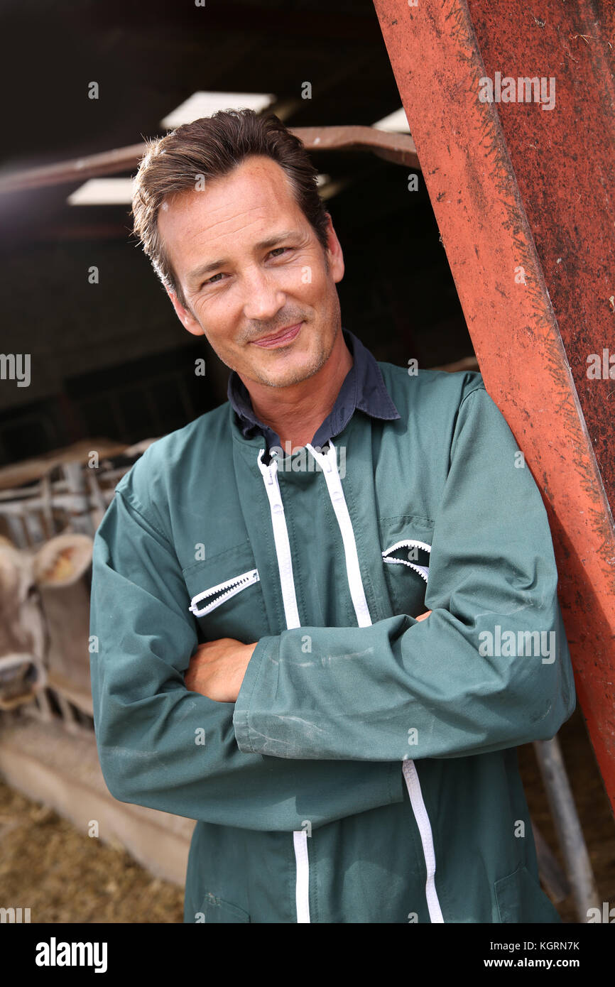 Smiling farmer standing in barn Stock Photo - Alamy