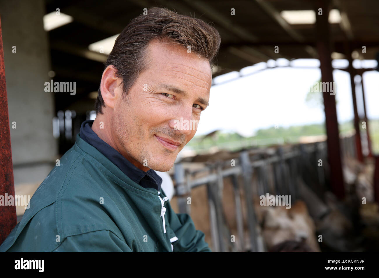 Smiling farmer standing in barn Stock Photo - Alamy