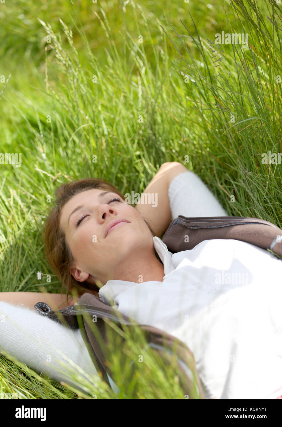 Woman relaxing in country field by sunny day Stock Photo - Alamy