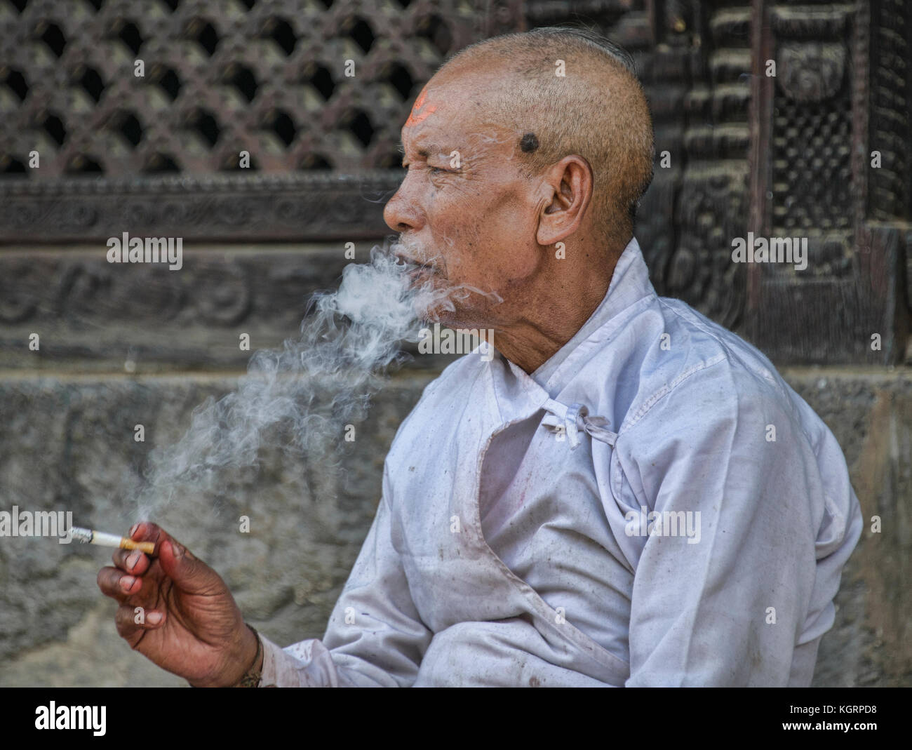 Goat butcher taking a cigarette break during Dasain Festival, Bhaktapur ...