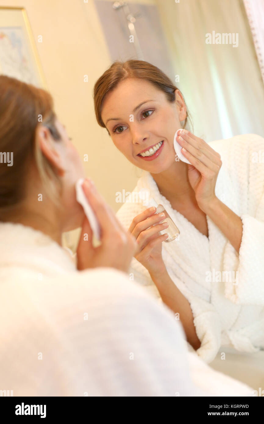 Beautiful woman in bathroom taking makeup off Stock Photo - Alamy