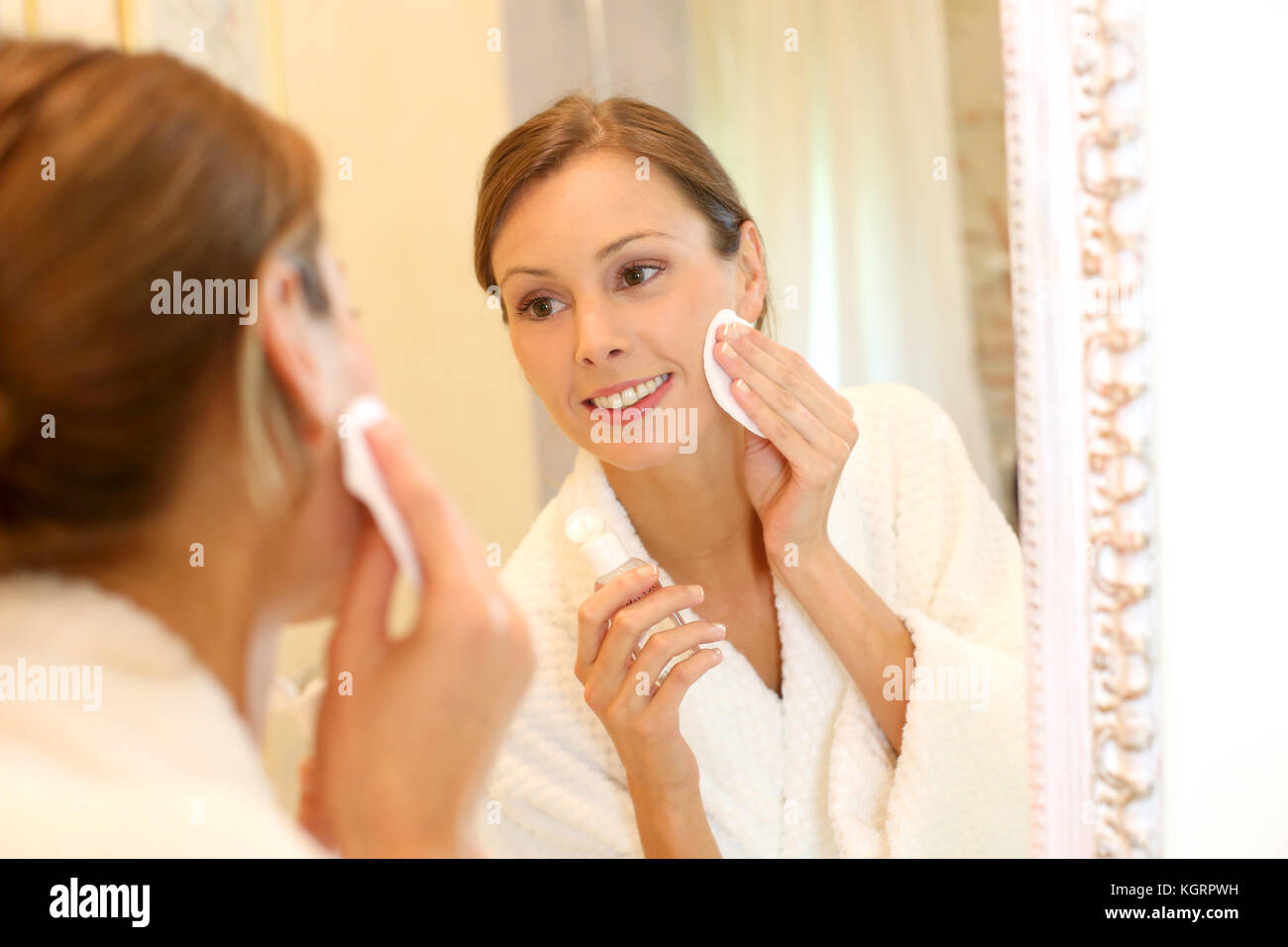 Beautiful woman in bathroom taking makeup off Stock Photo - Alamy