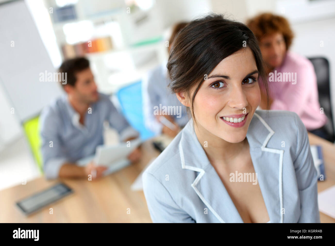 Cheerful young businesswoman in work meeting Stock Photo - Alamy