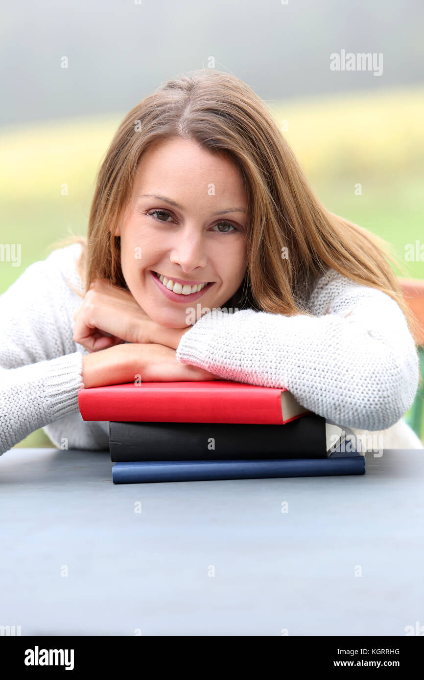 Portrait of beautiful girl leaning on books Stock Photo - Alamy