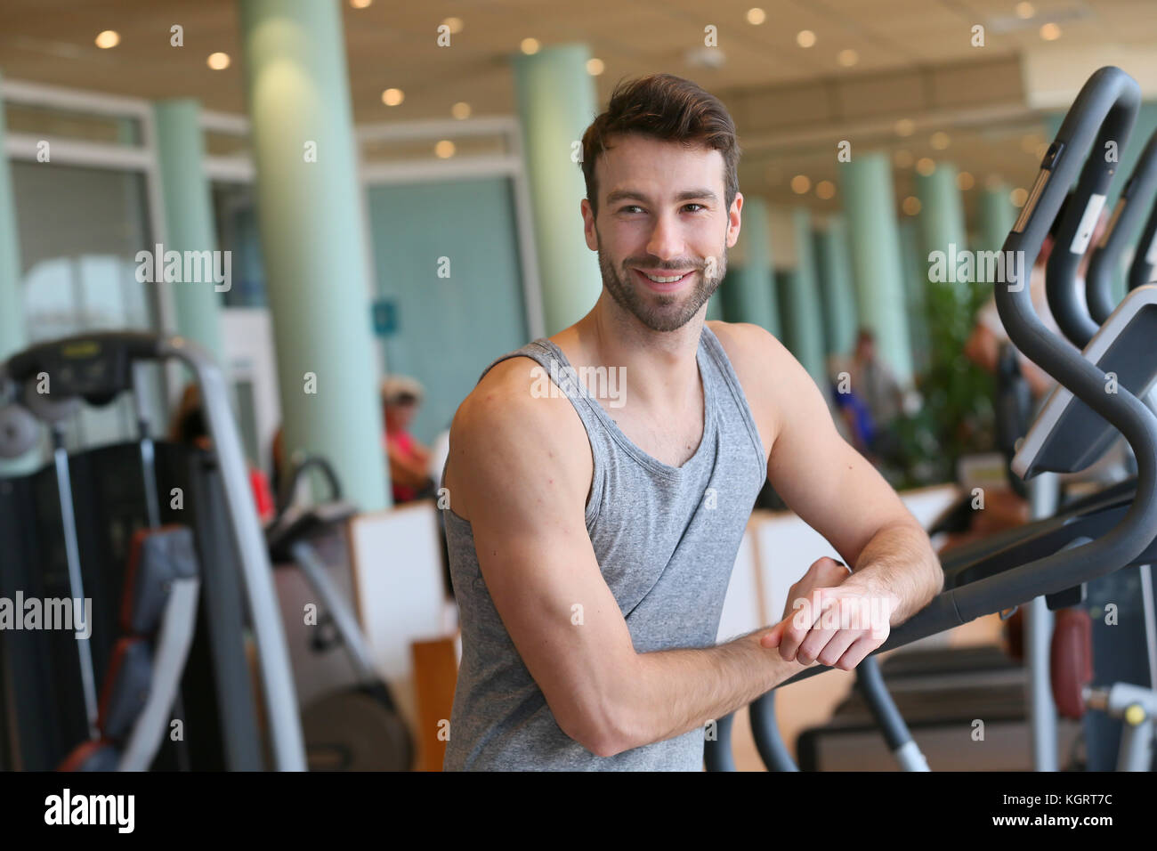 Athletic man standing by treadmill in gym Stock Photo - Alamy