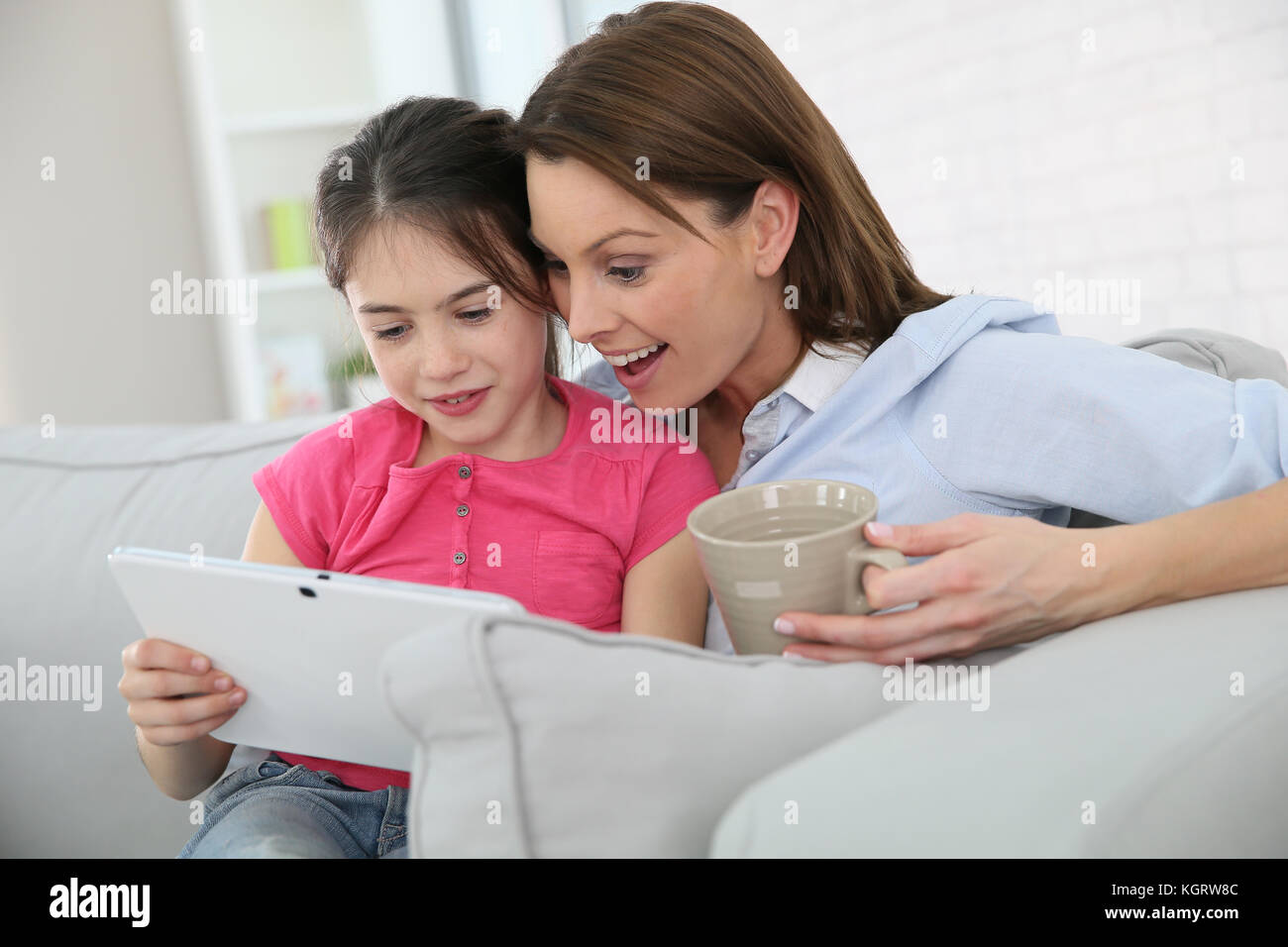 Mother with little girl websurfing on tablet Stock Photo - Alamy