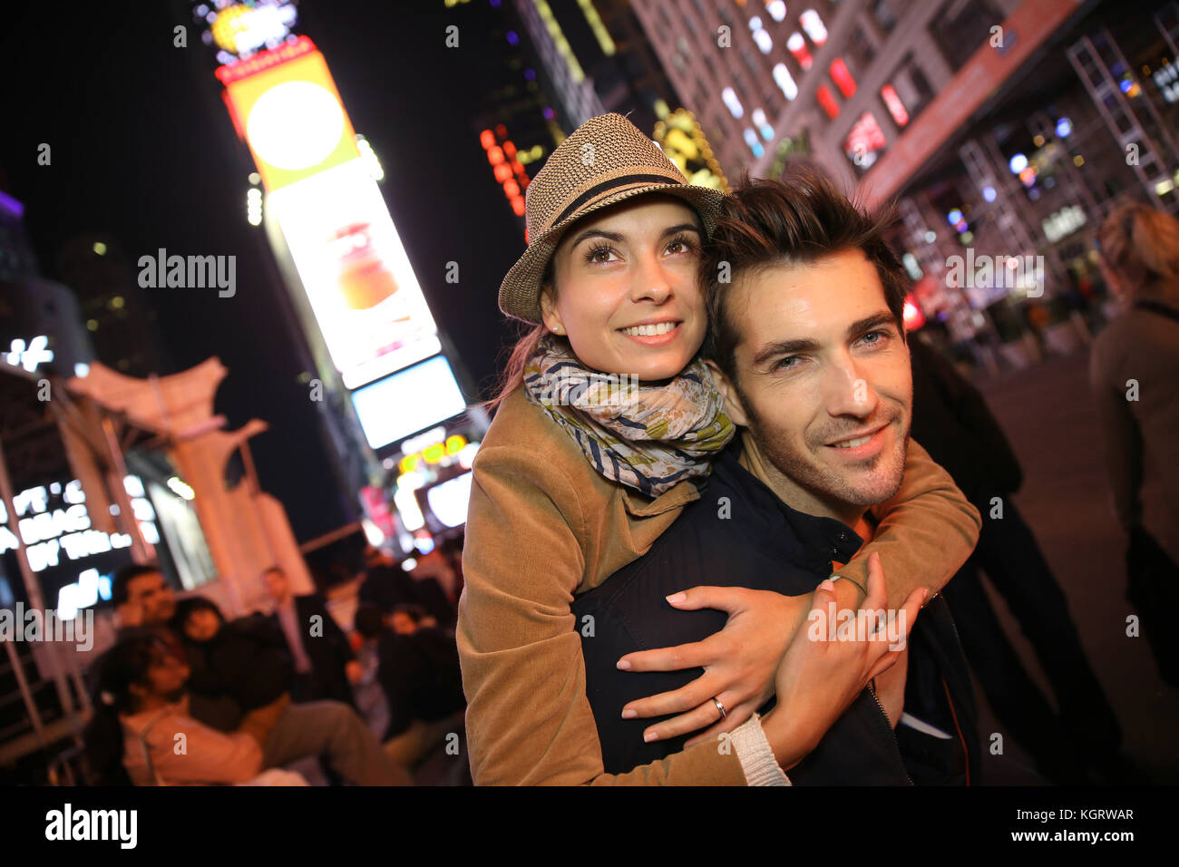 Couple standing in Time Square quarter by night Stock Photo - Alamy